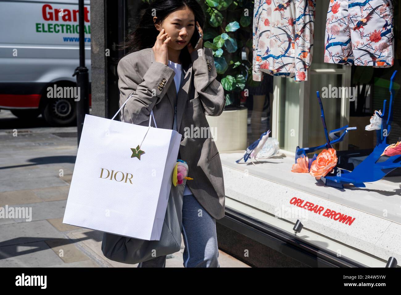 London, UK. 30 May 2023. A tourist with a Dior designer bag in New Bond Street. Representatives ...