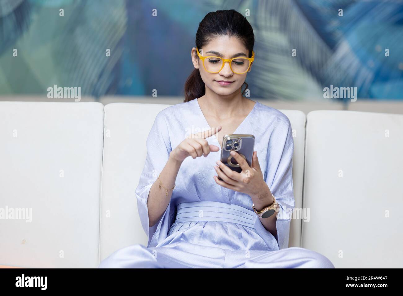 Happy indian lady relax at home alone sit on large couch in comfortable ...