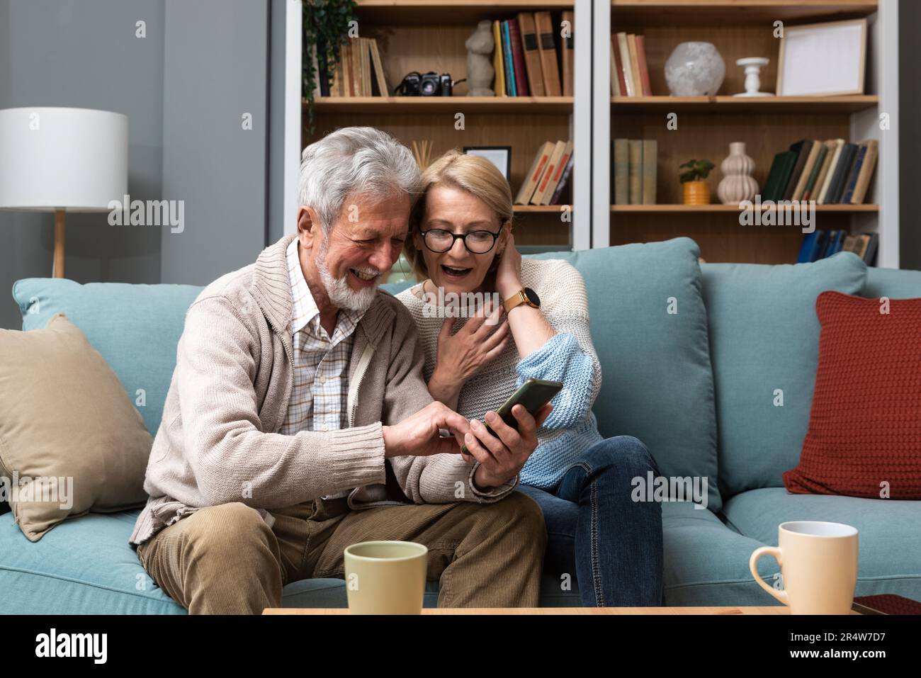 Relaxed mature 60s woman and 70s man older aged senior couple customer ...