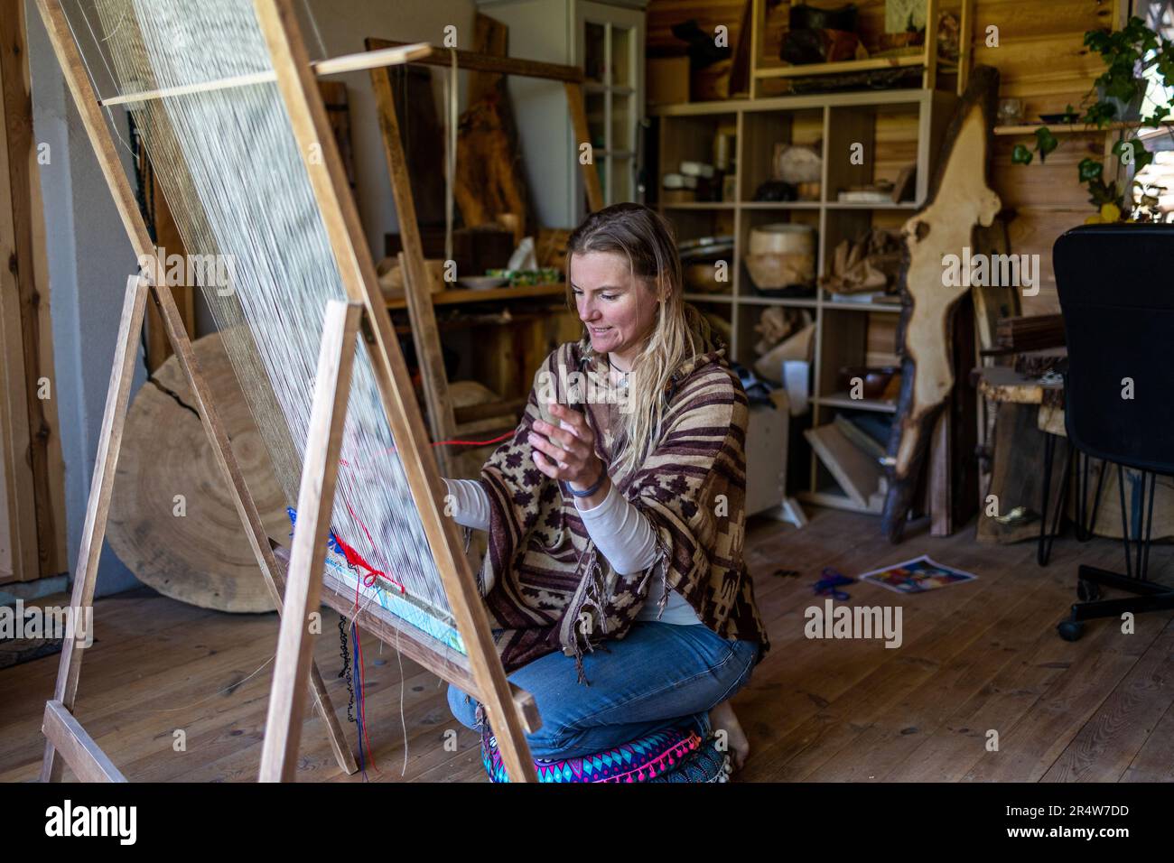 Crafty woman weaving at a loom at her workshop Stock Photo - Alamy