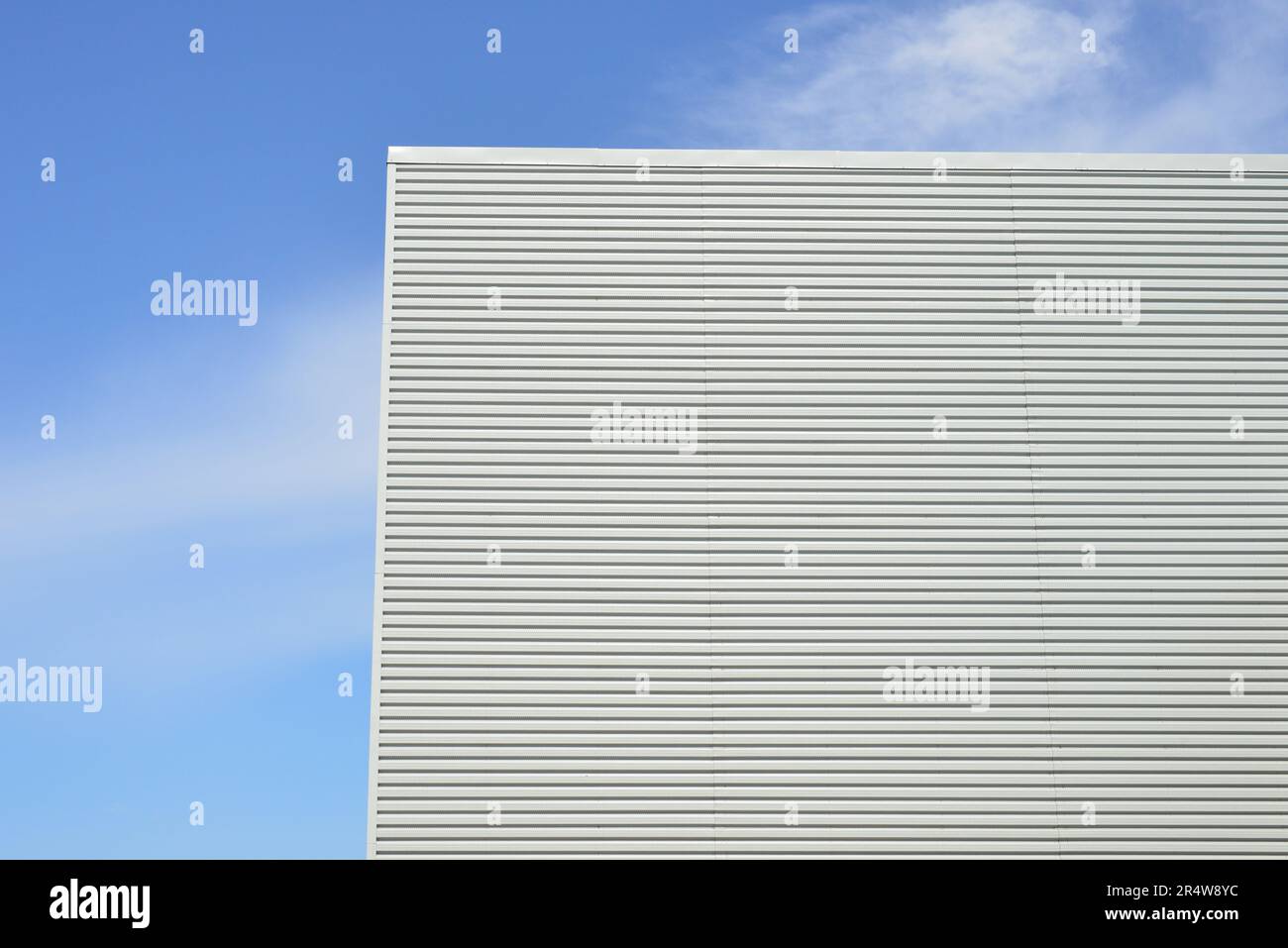 The exterior wall of a white commercial building. The metal horizontal ...