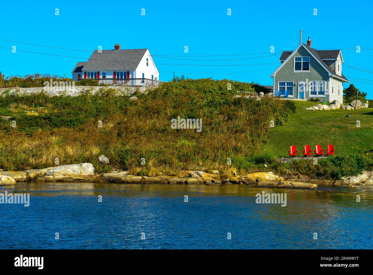 Two colorful wooden cottages with patios on a hill overlooking the blue ...