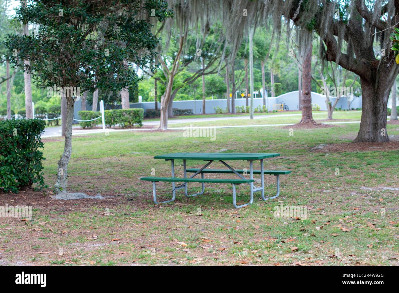 An empty green wooden picnic table with metal legs. The park table is ...