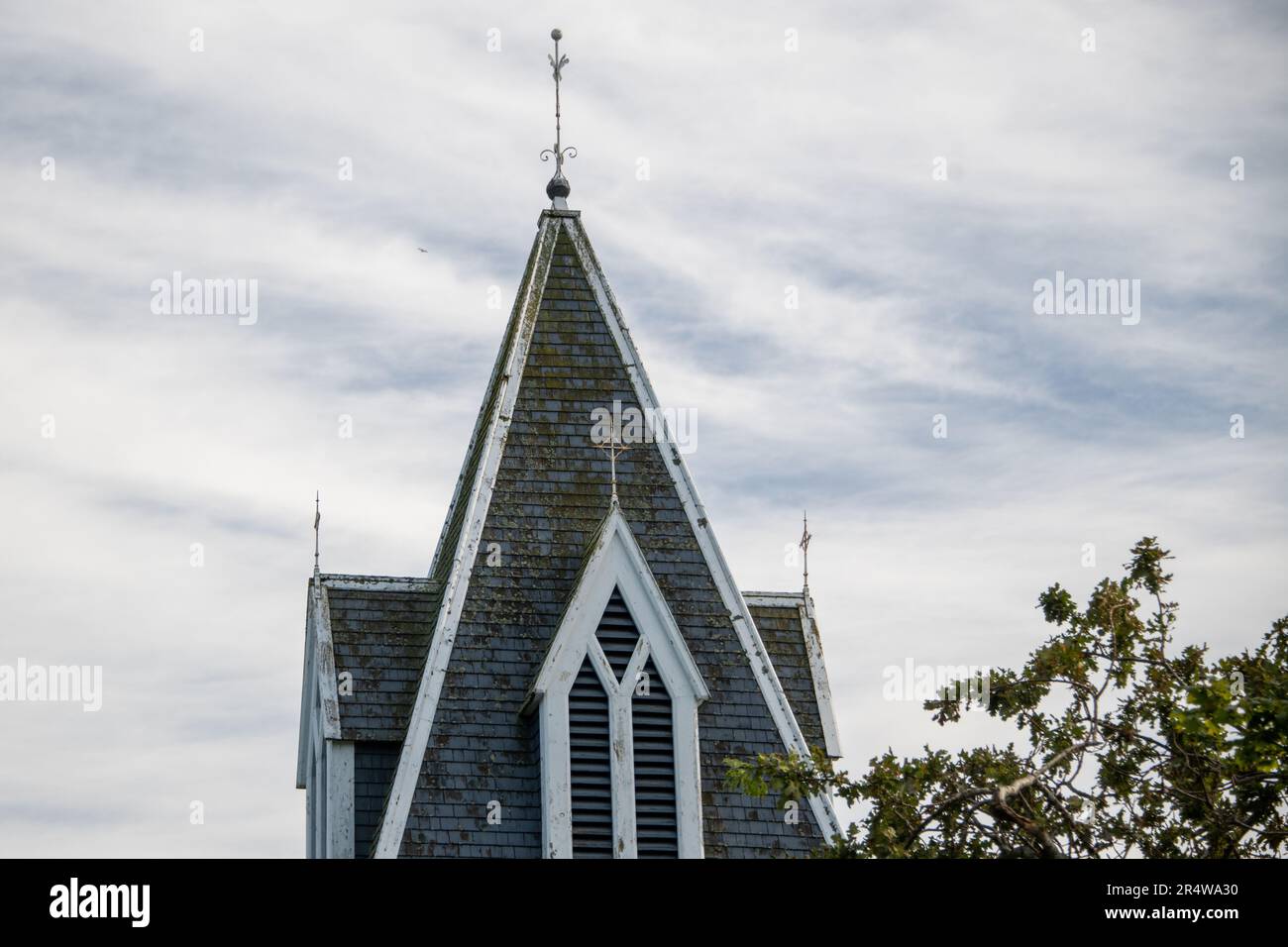 A dark blue colored wooden Catholic square steeple of a religious ...