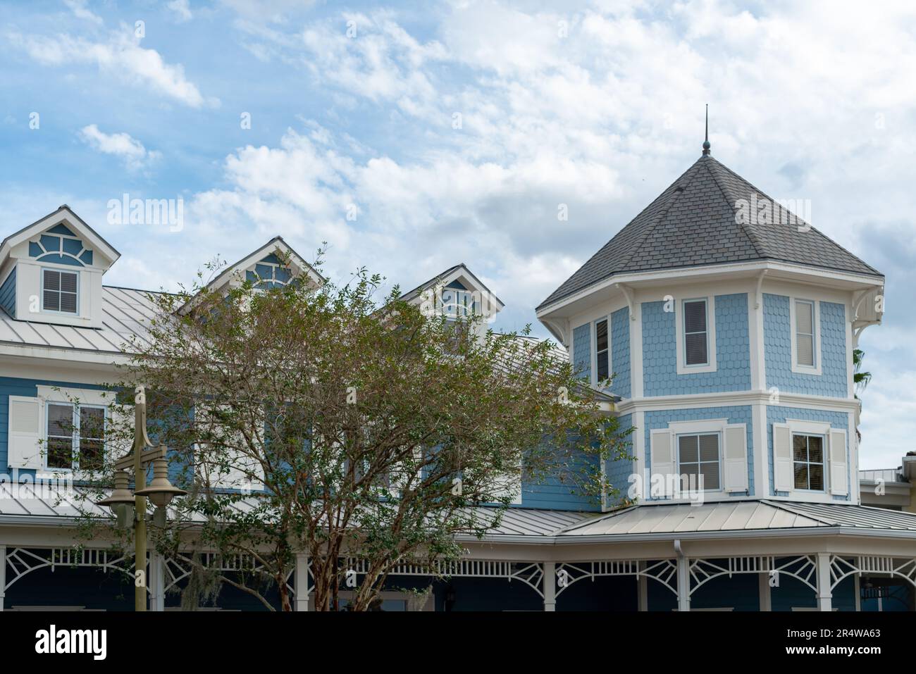 A pale blue wooden historic home with a rounds shaped turret. The large ...