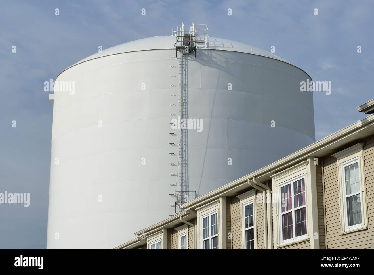 The exterior of a tall white metal industrial cylinder tower with a ...