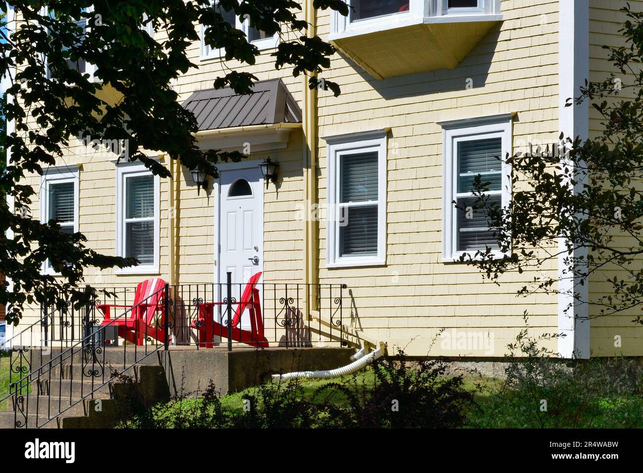 The exterior of a vintage yellow colored wooden clapboard country style ...
