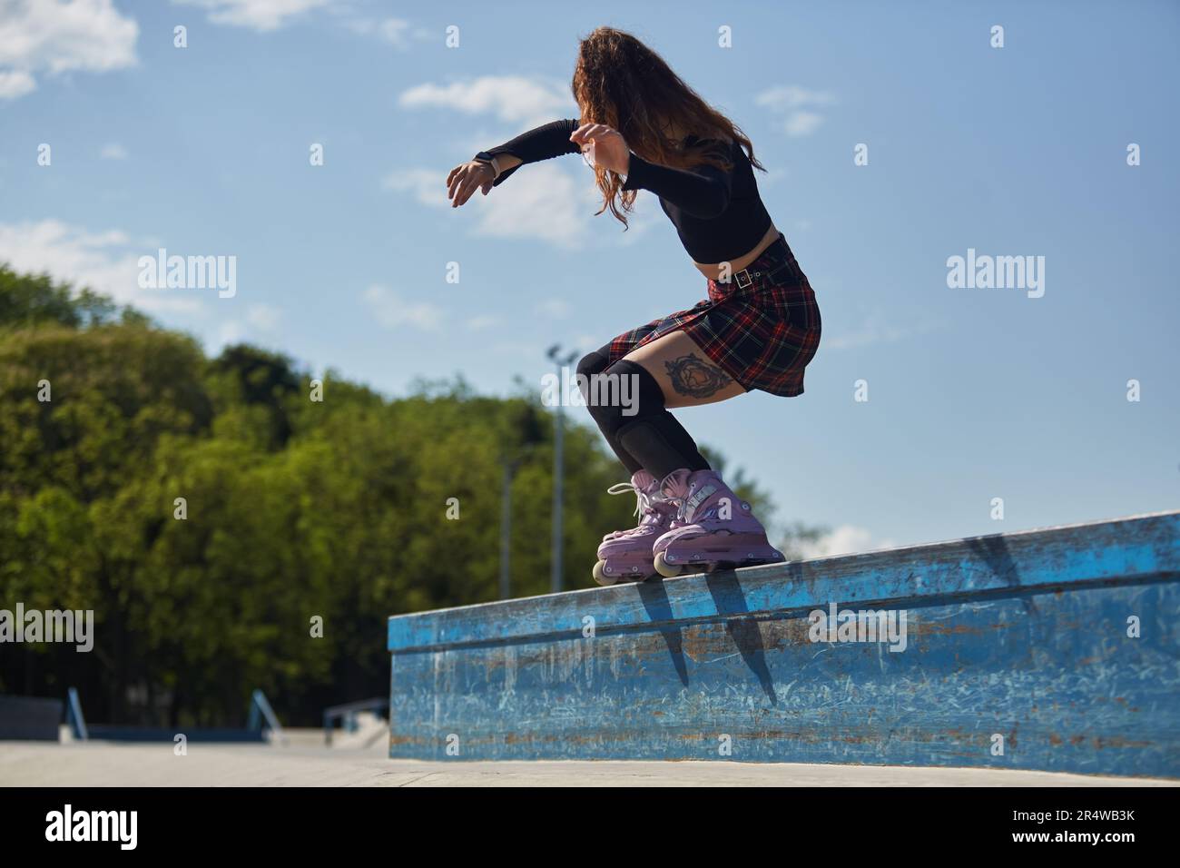 Young roller blader grinding on a ledge in a skatepark. Cool female ...
