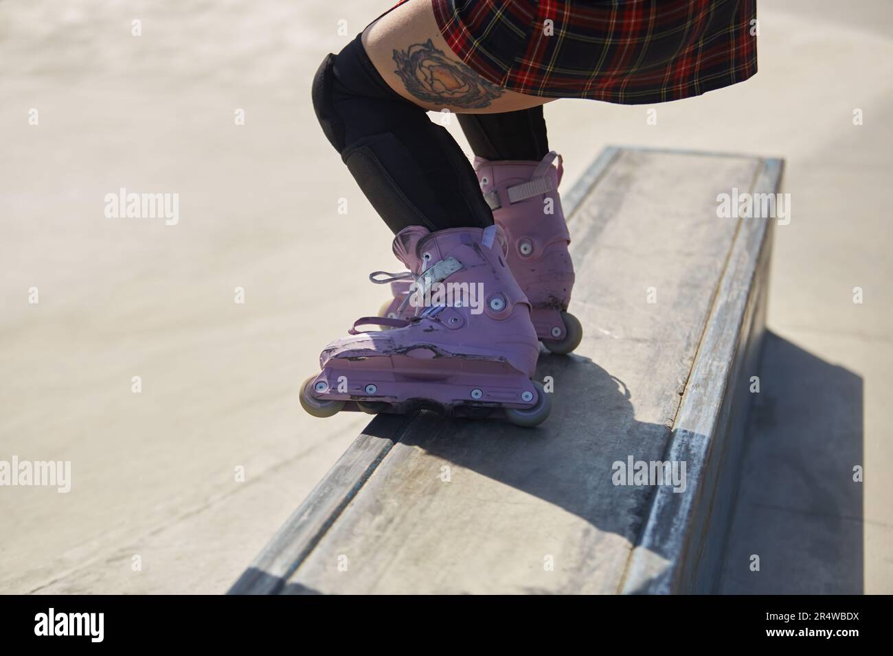 Skater girl grinding on a ledge in a skatepark. Feet of aggressive ...
