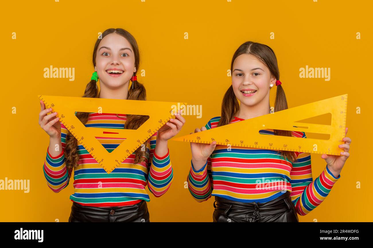 happy school kids hold math tool of triangle Stock Photo - Alamy
