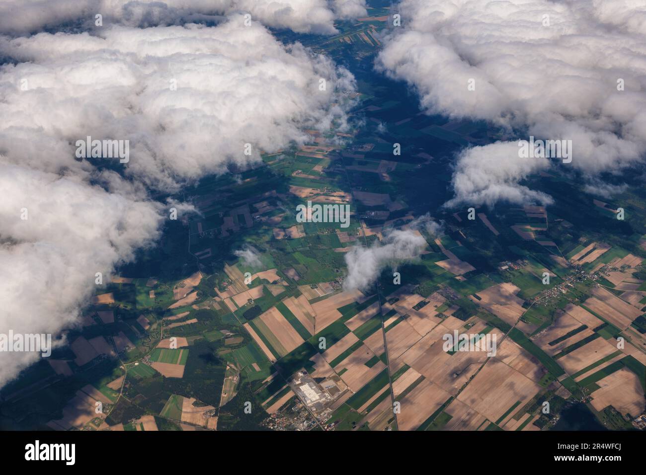 Aerial view over agricultural farm fields and cumulus clouds in Poland ...