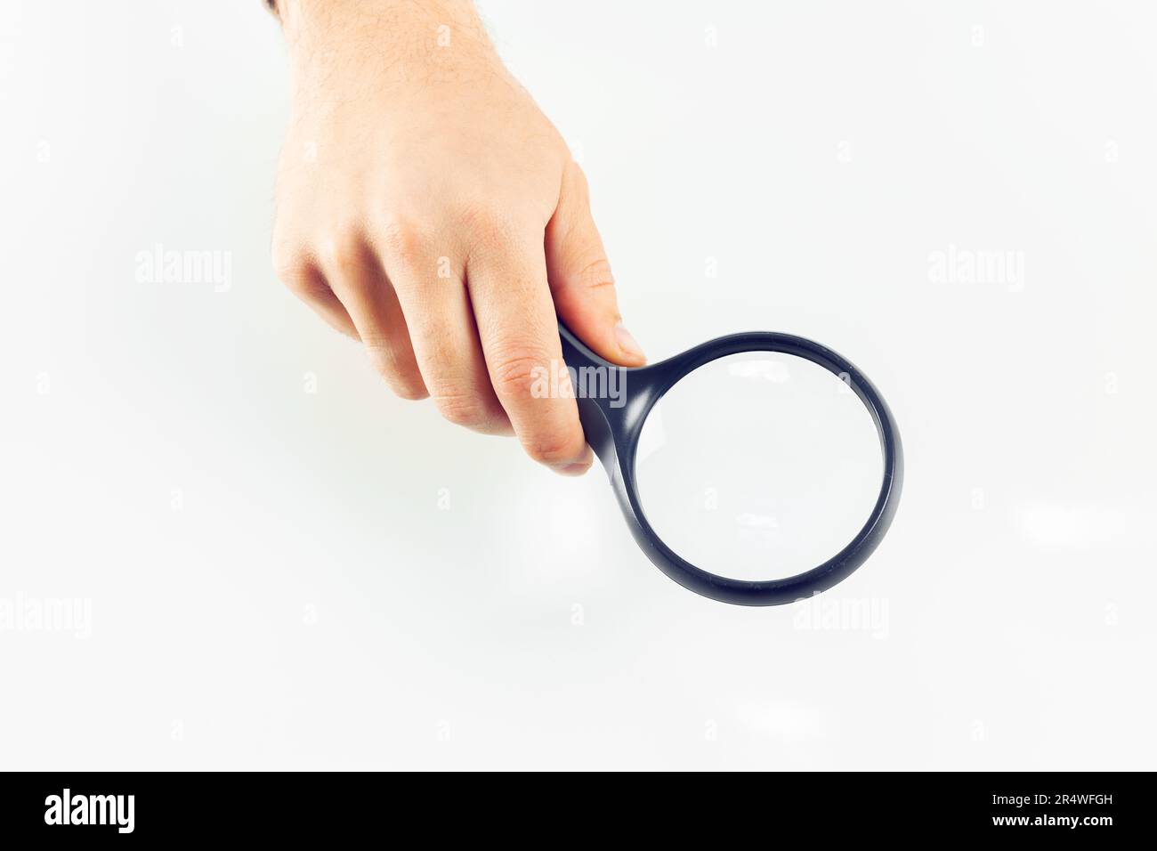 Hand with magnifying glass on white background Stock Photo - Alamy