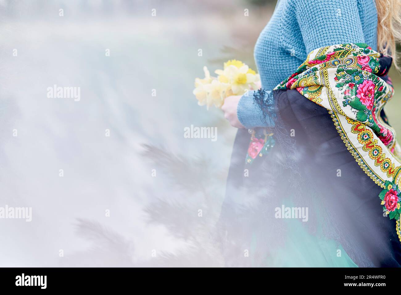 Woman in blur effect with nature reflection. Woman hands hold daffodils ...