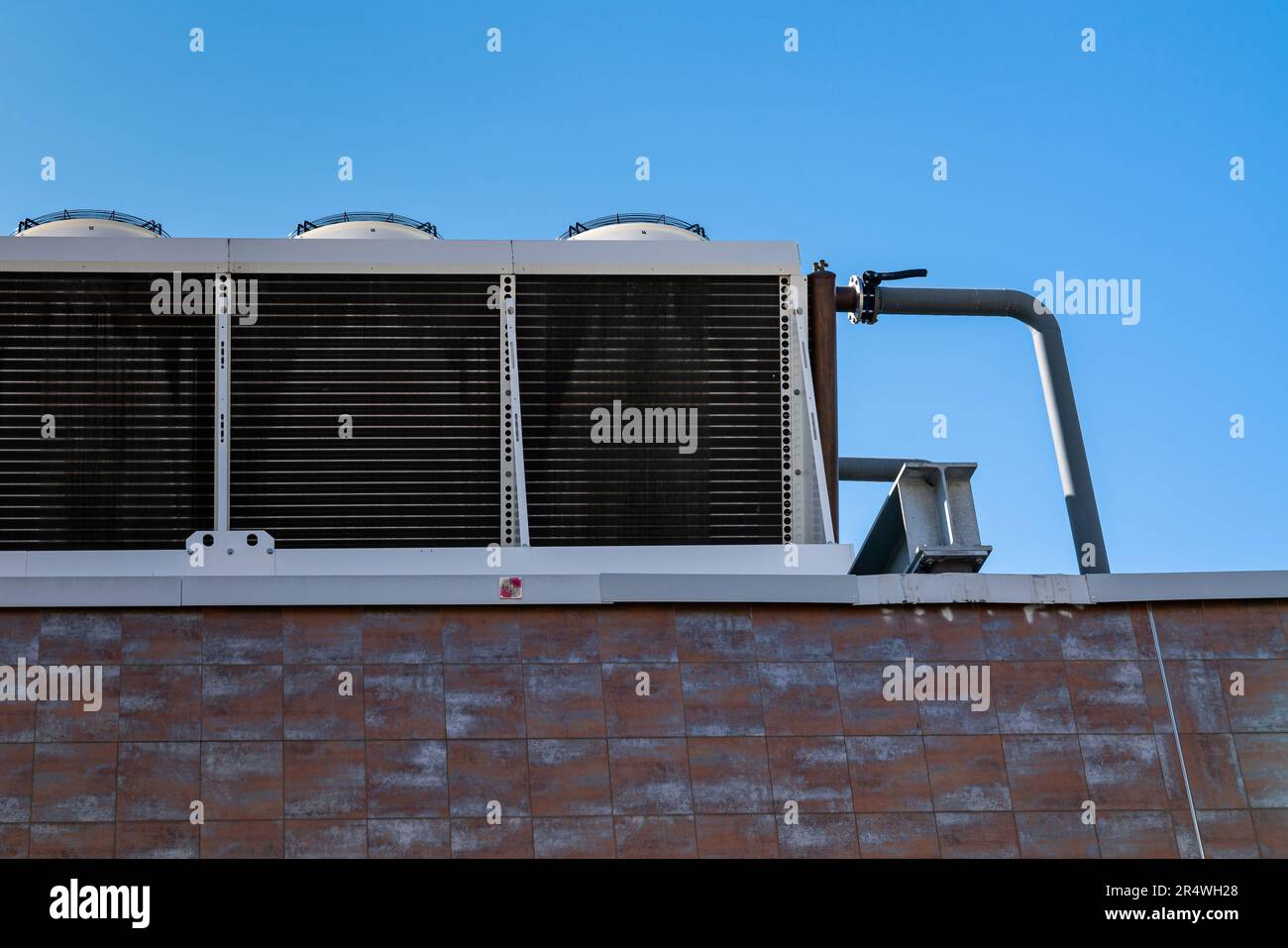 Ventilation exhaust system on the roof of a brick building against the ...