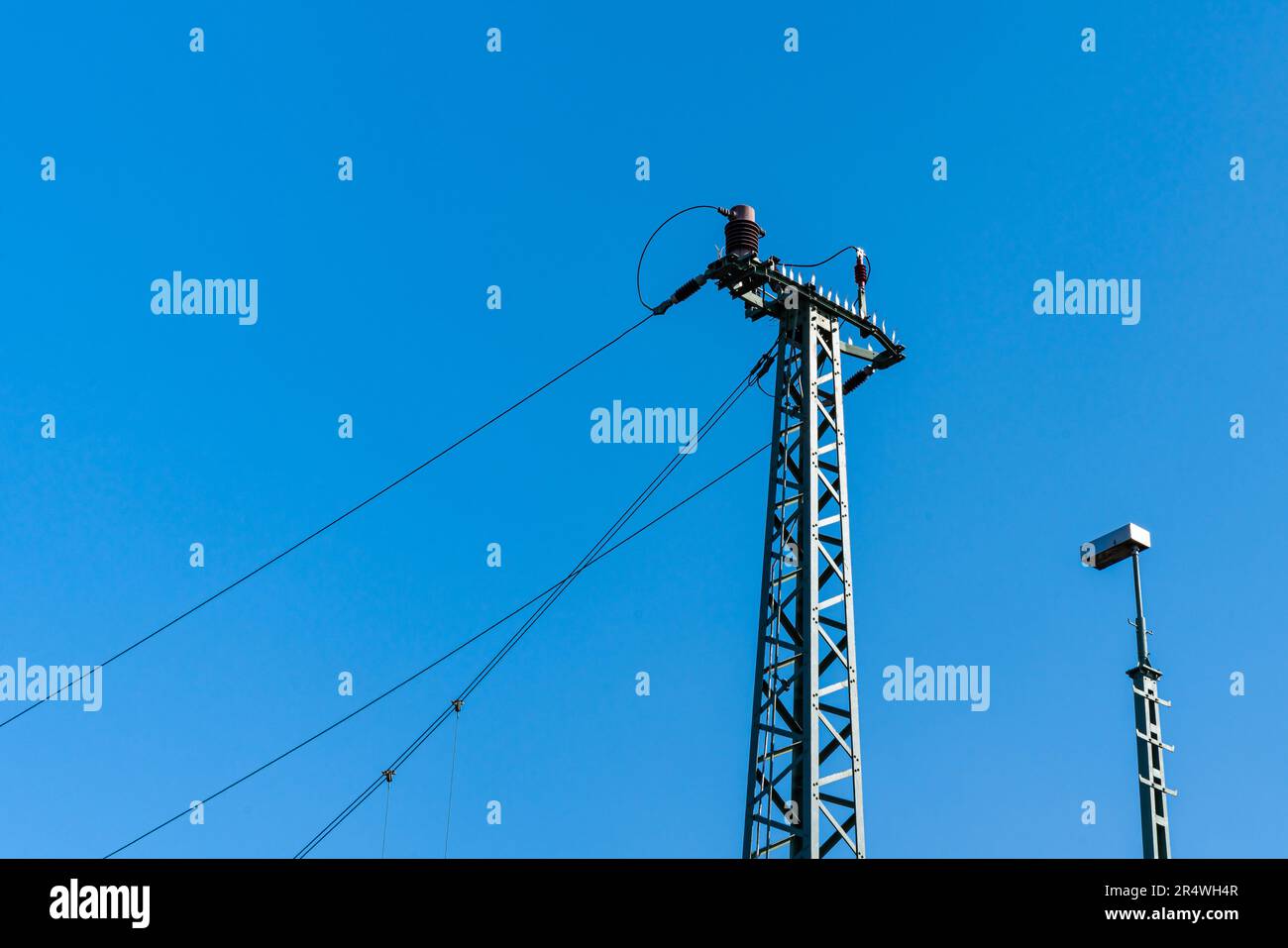Metal mast with electrical wires against the clean blue sky Stock Photo ...