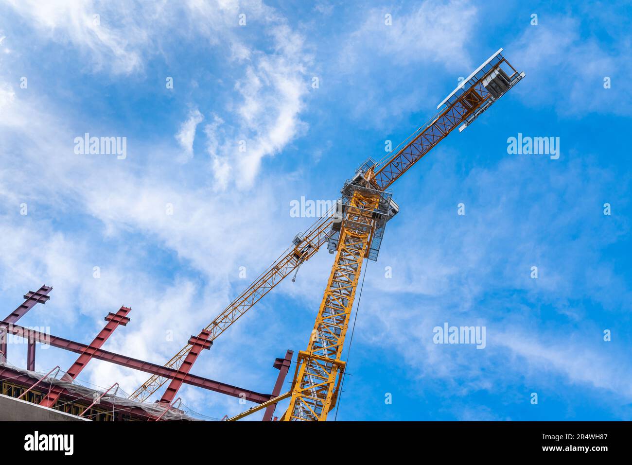View of the tower crane cabin from below. Blue sky with light white ...