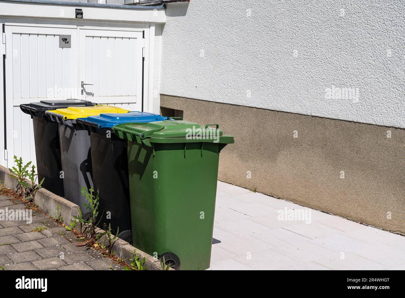 Multi-colored plastic bins for separate waste collection standing in a ...