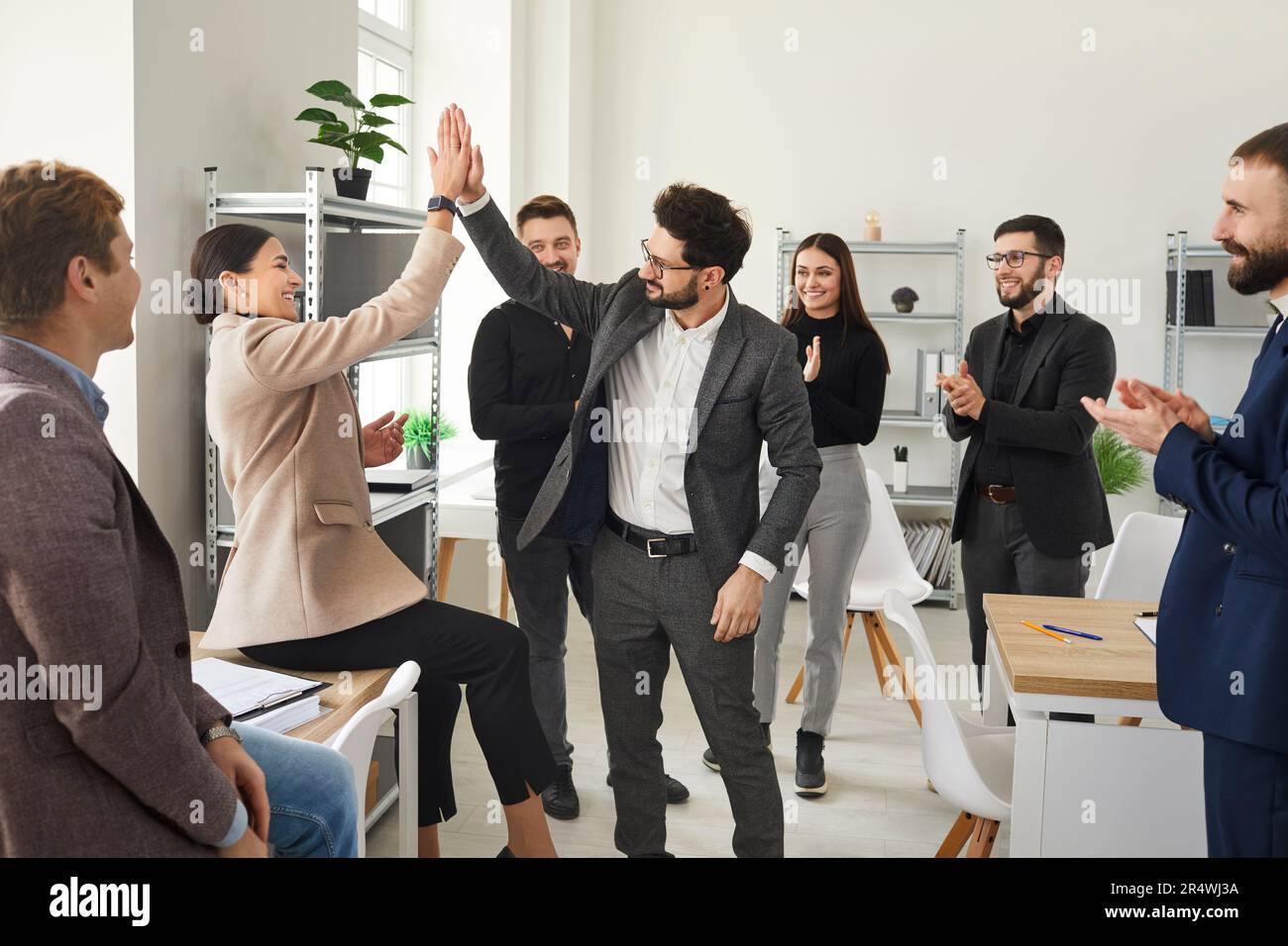 Happy colleagues giving high five at meeting at office, celebrating ...