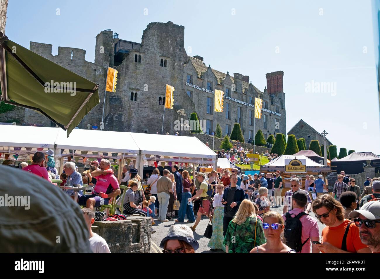 View of Hay castle from town centre during Hay Festival & visitors enjoying fair in the square ...