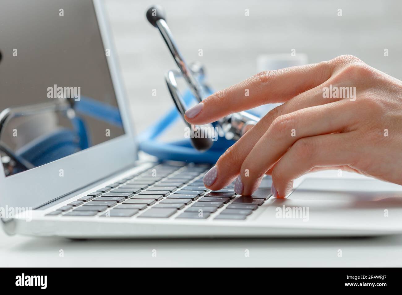 Female doctor is typing in laptop computer Stock Photo - Alamy
