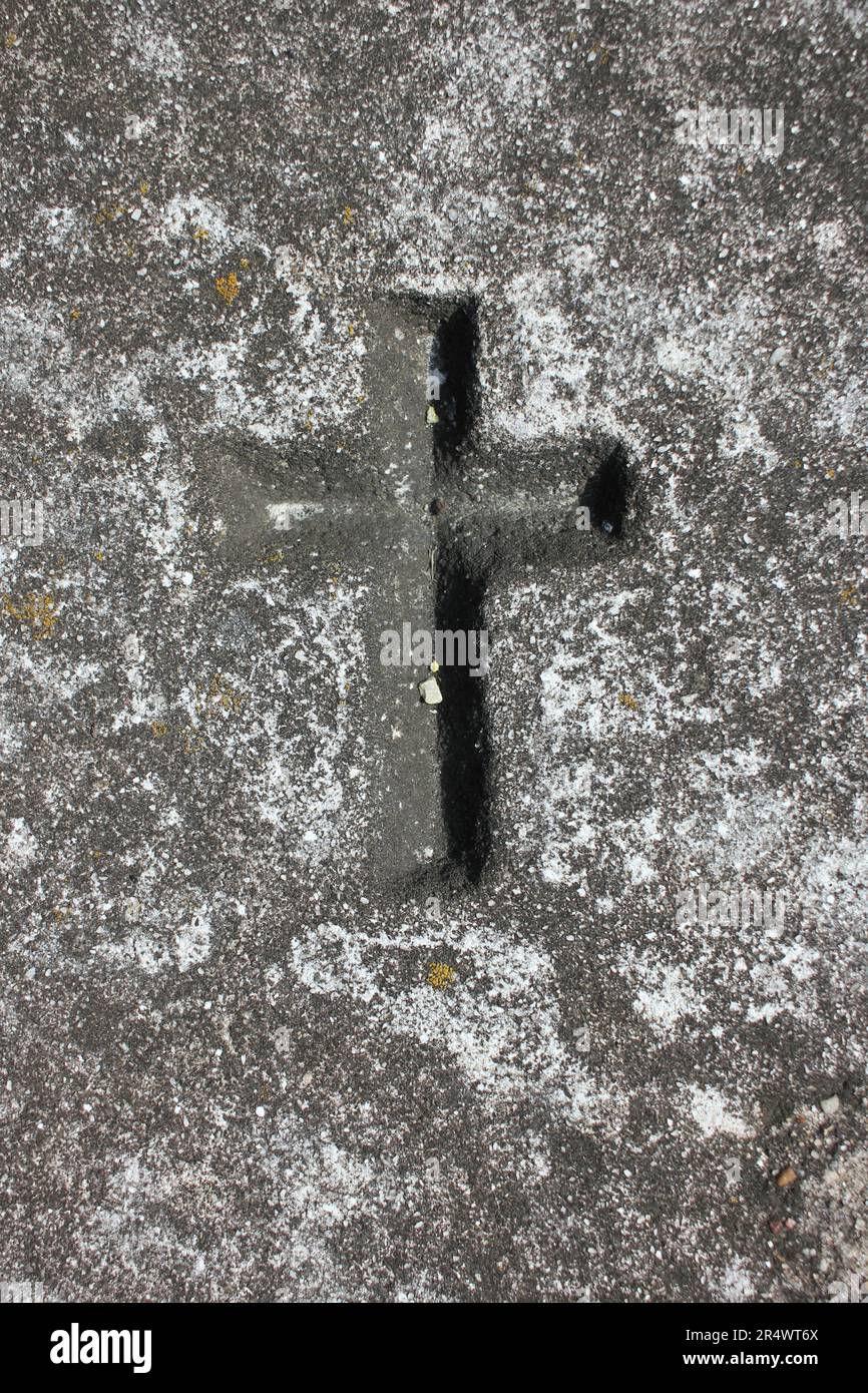 A simple cross carved into a vintage natural stone wall Stock Photo - Alamy