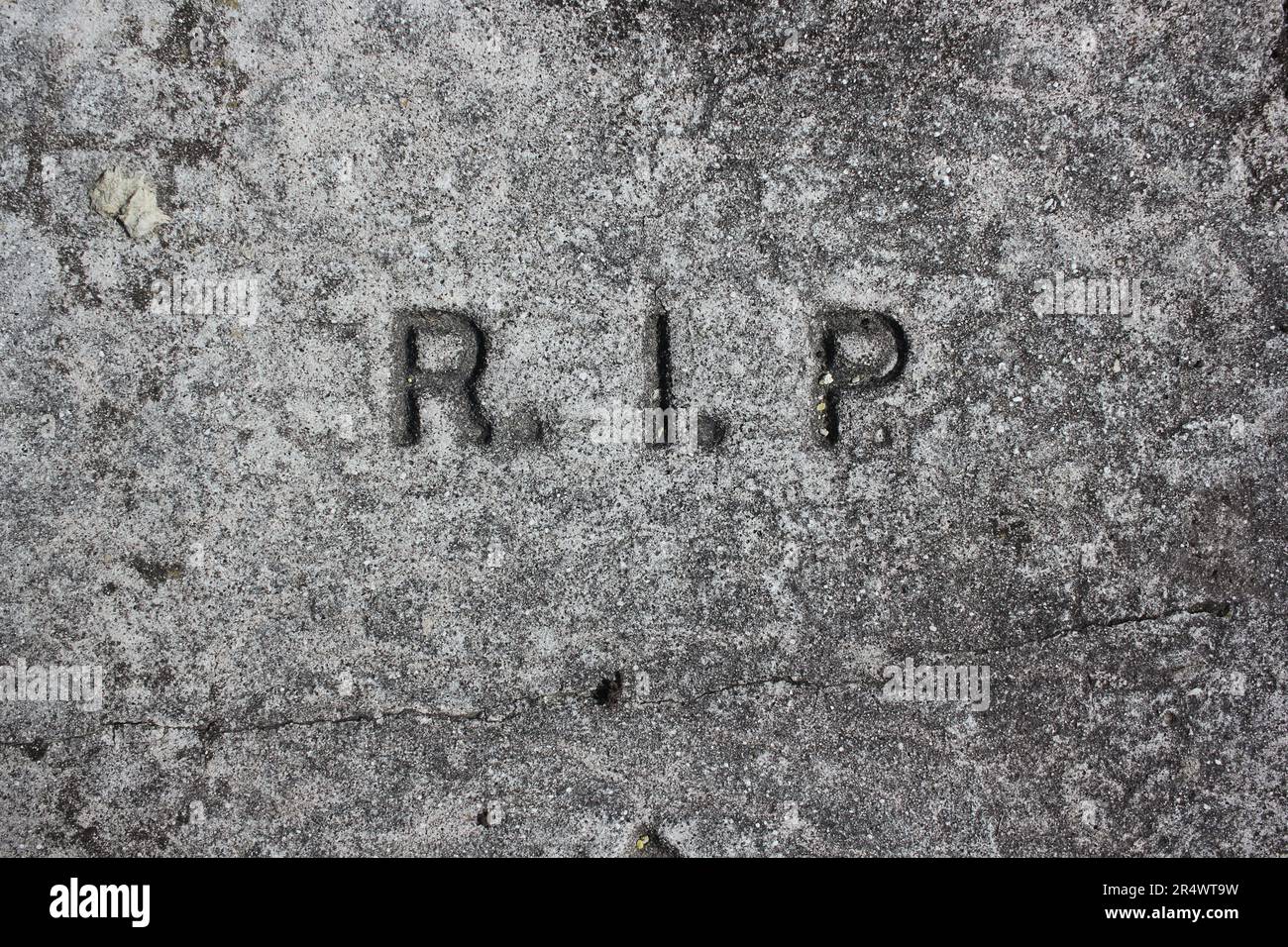 RIP, rest in peace, carved into the worn and weathered natural stone ...