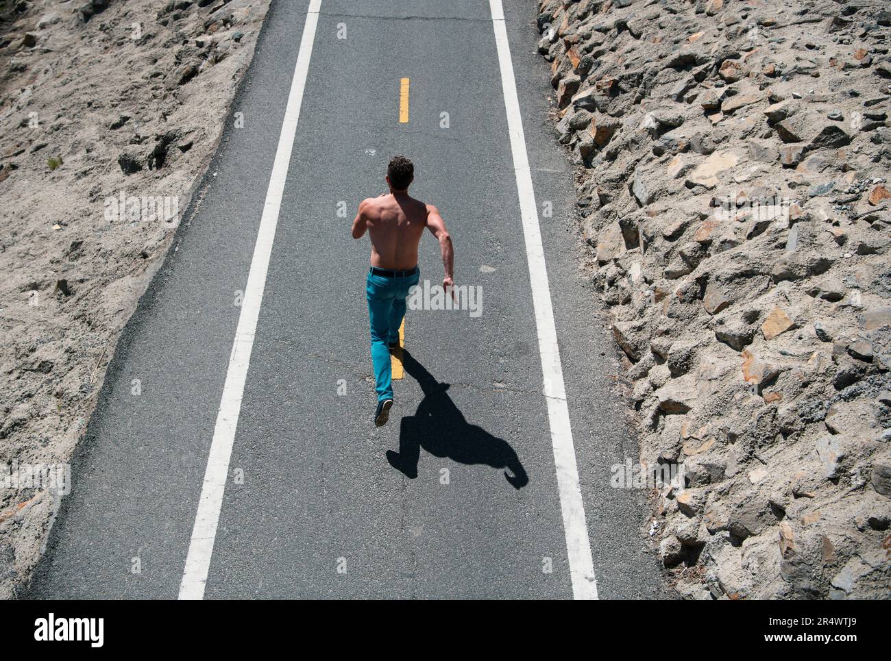 Back view of athletic young man running with naked torso. Sport and ...