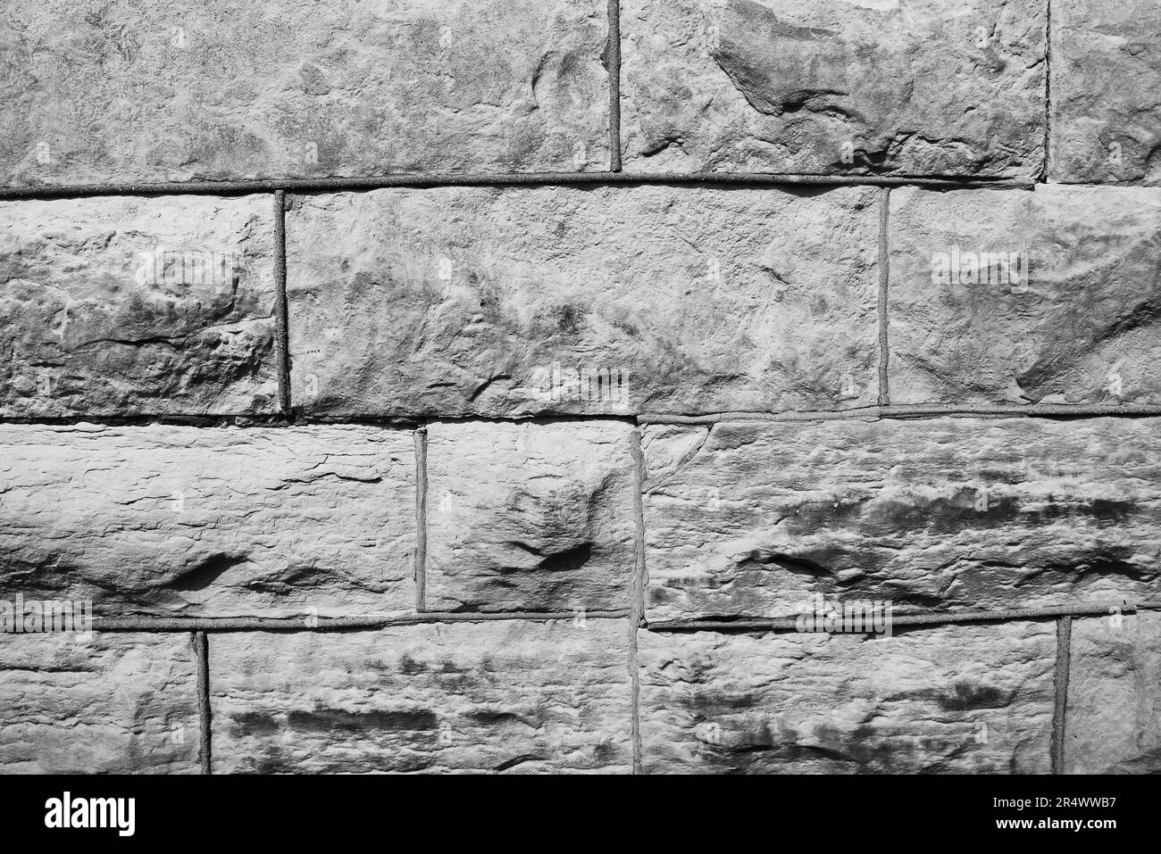 A traditional natural stone block wall in a black and white monochrome ...