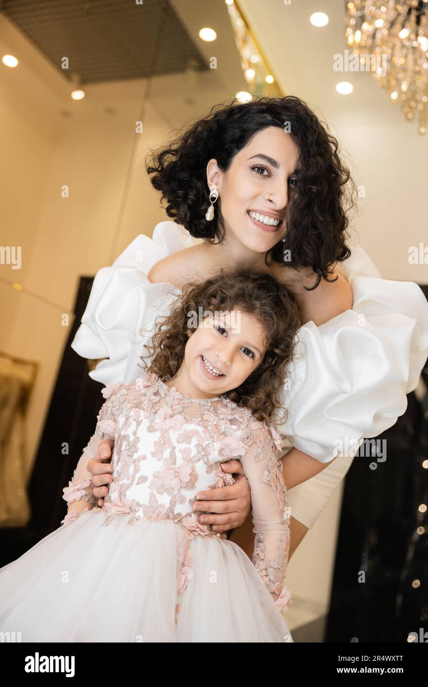 charming middle eastern bride with brunette hair standing in white ...