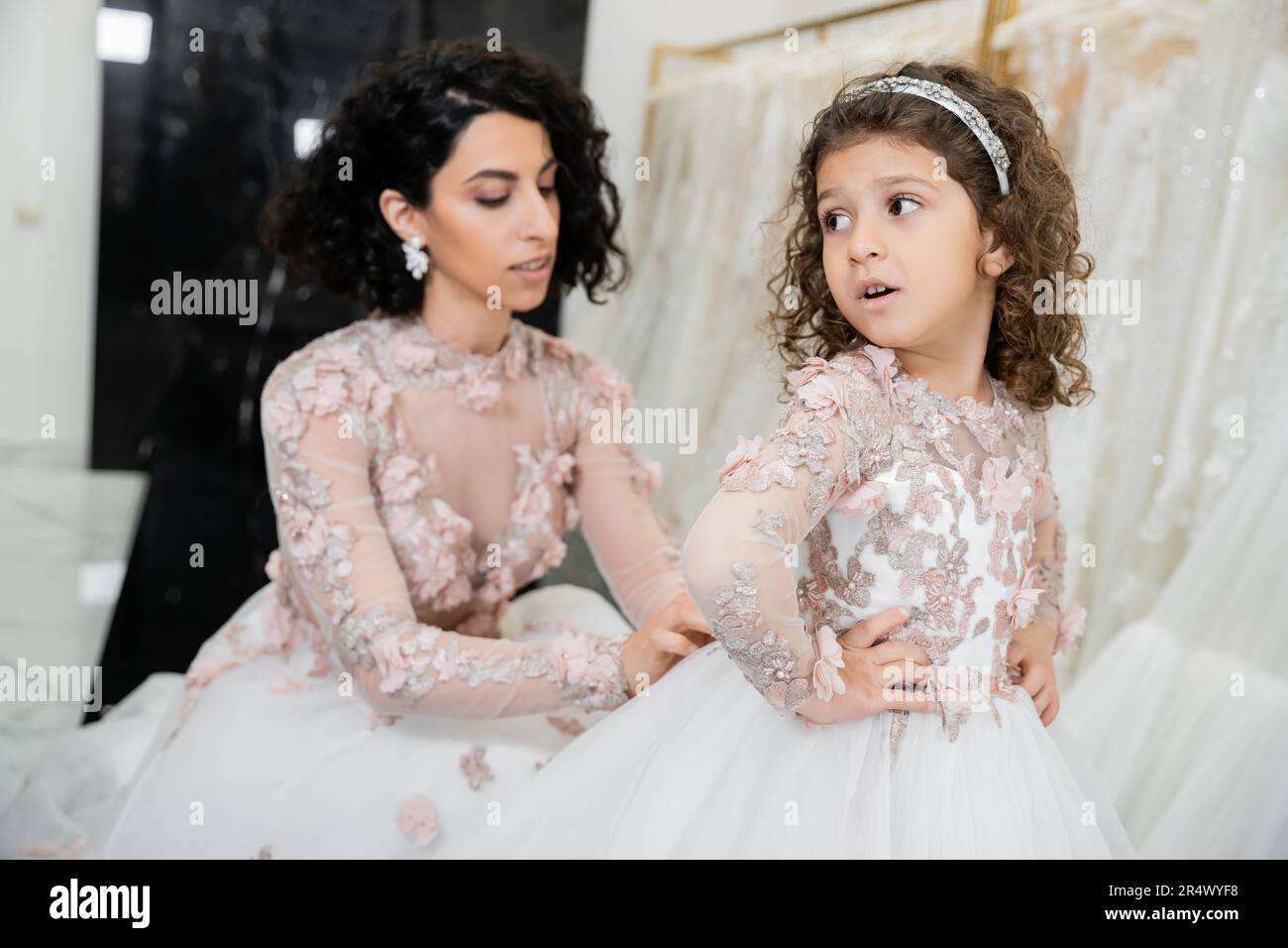 blurred middle eastern bride with brunette wavy hair in wedding dress ...