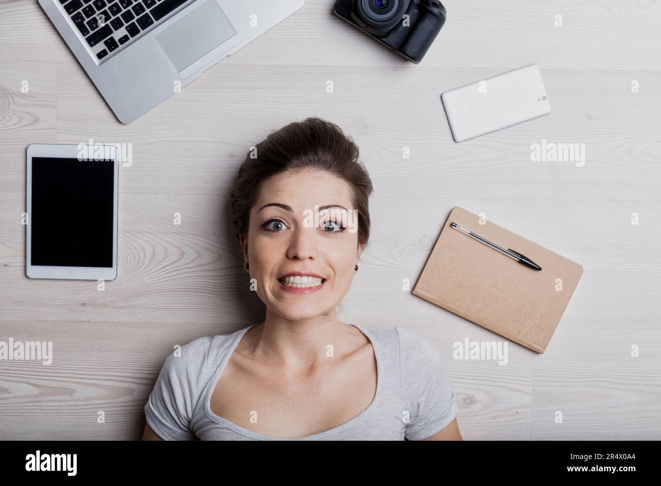 Young woman, cheerful yet tense. Wide-eyed, clenched teeth, smiling ...