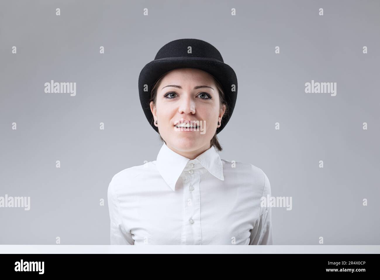 Young woman with bowler hat, semi-open lips, speaking to you. Half ...