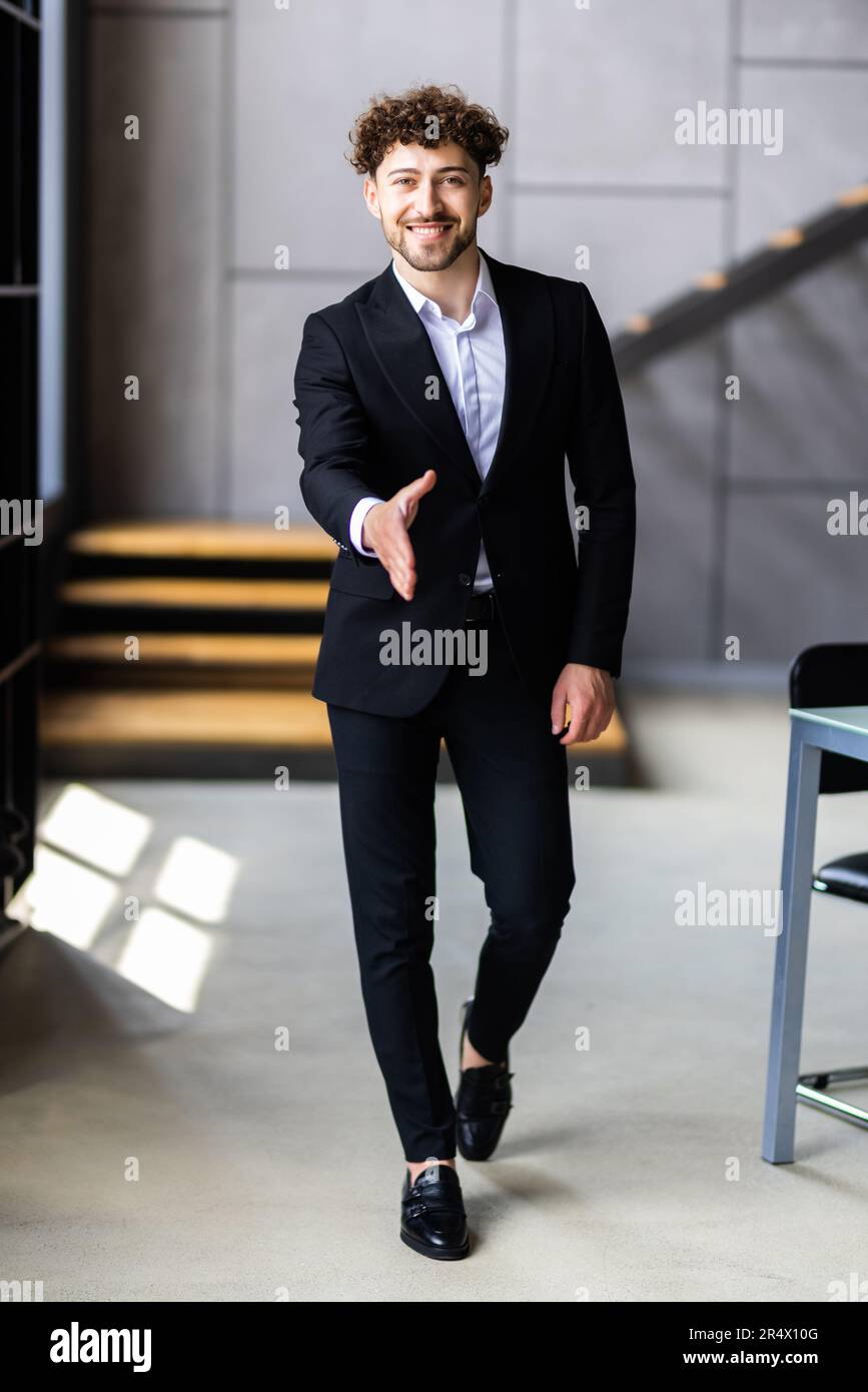 Male businessman in a suit stretching hand and shows a palm up gesture ...