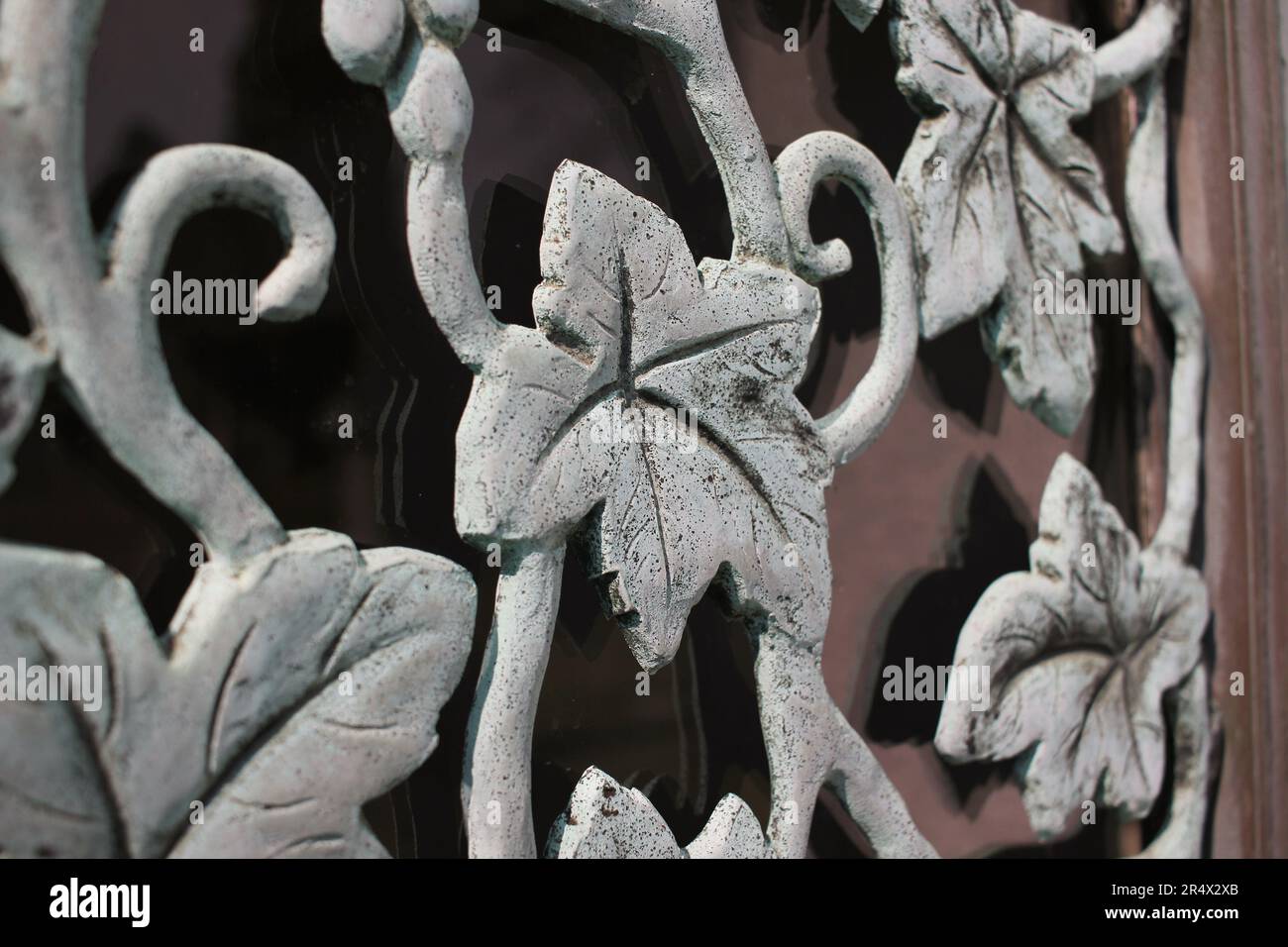 A beautiful closeup of a typical leaf cast in a copper metal fence ...