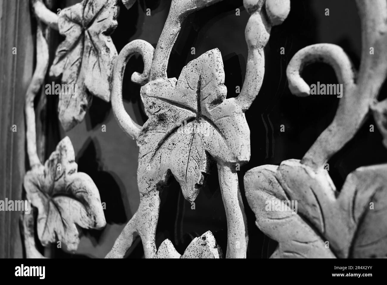A beautiful closeup of a typical leaf cast in a copper metal fence in a ...