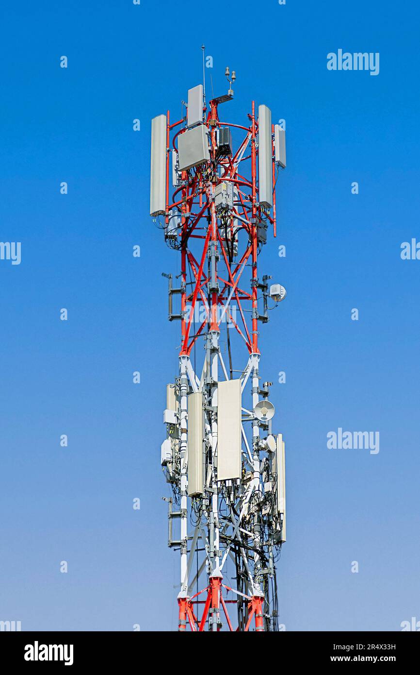 Tall cell tower antenna mast with blue sky in background Stock Photo - Alamy