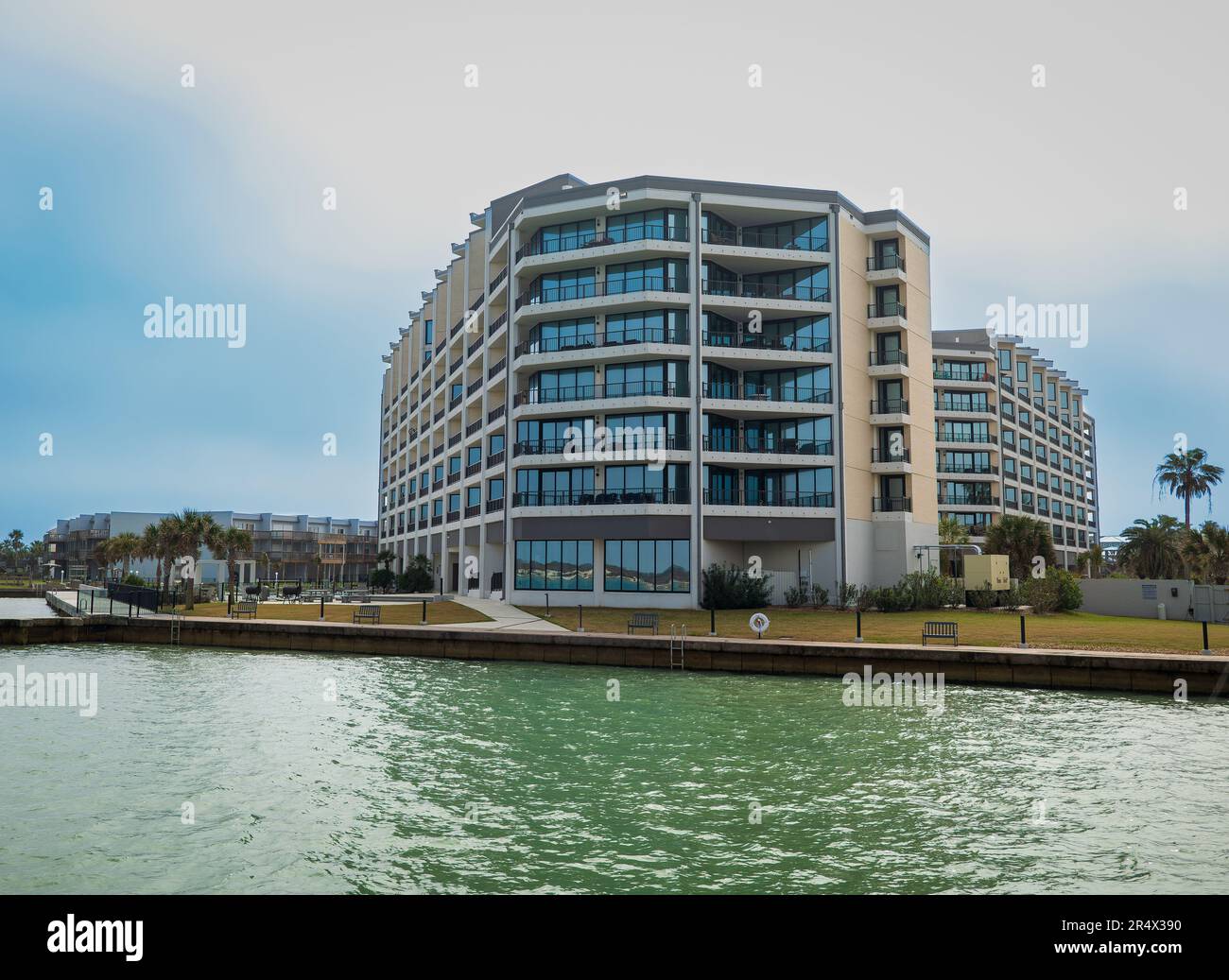 Modern waterfront condominium building with multiple stories, on a ...
