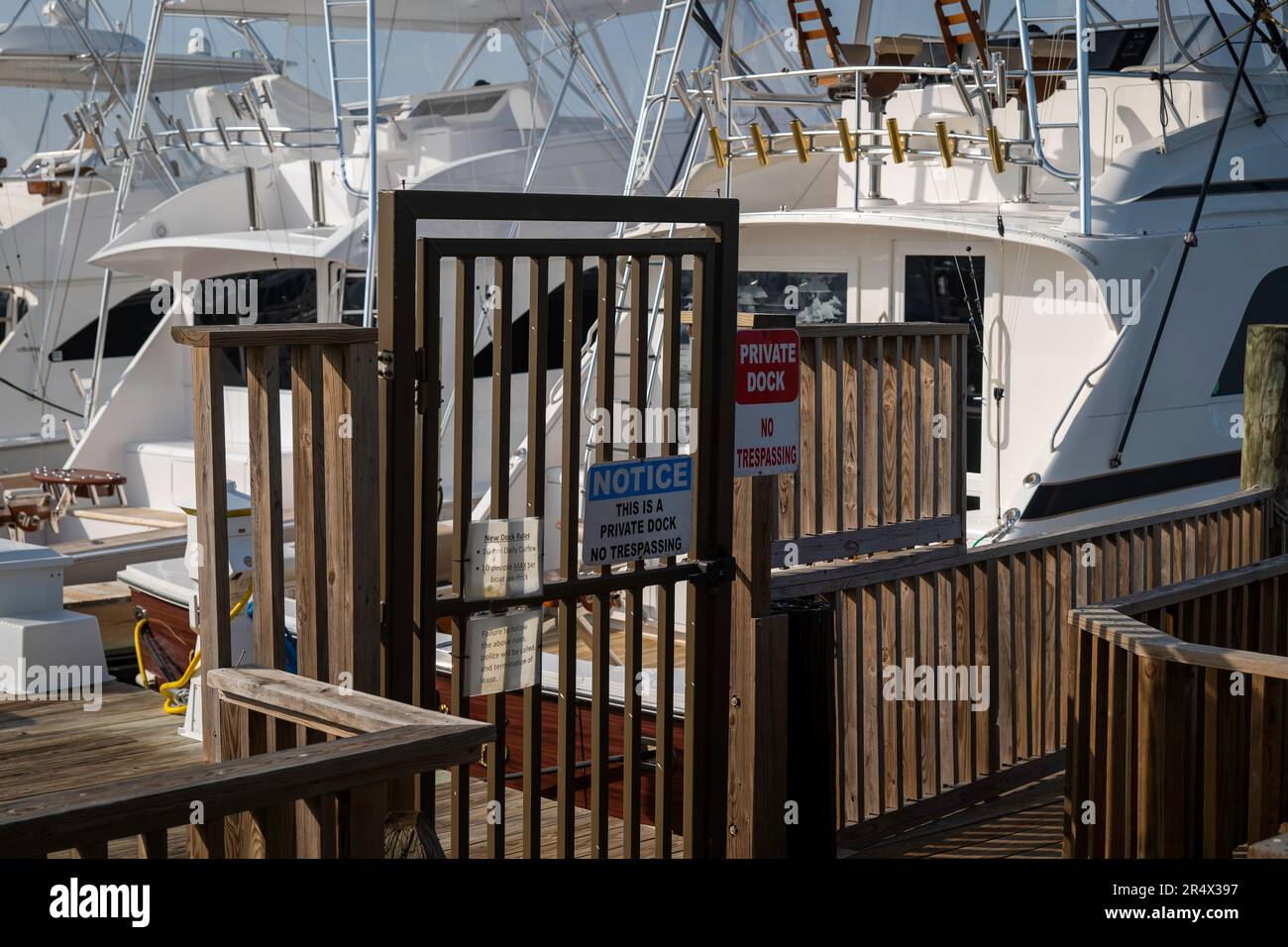 Gate entrance to a private marina dock with fishing boats, with signs ...