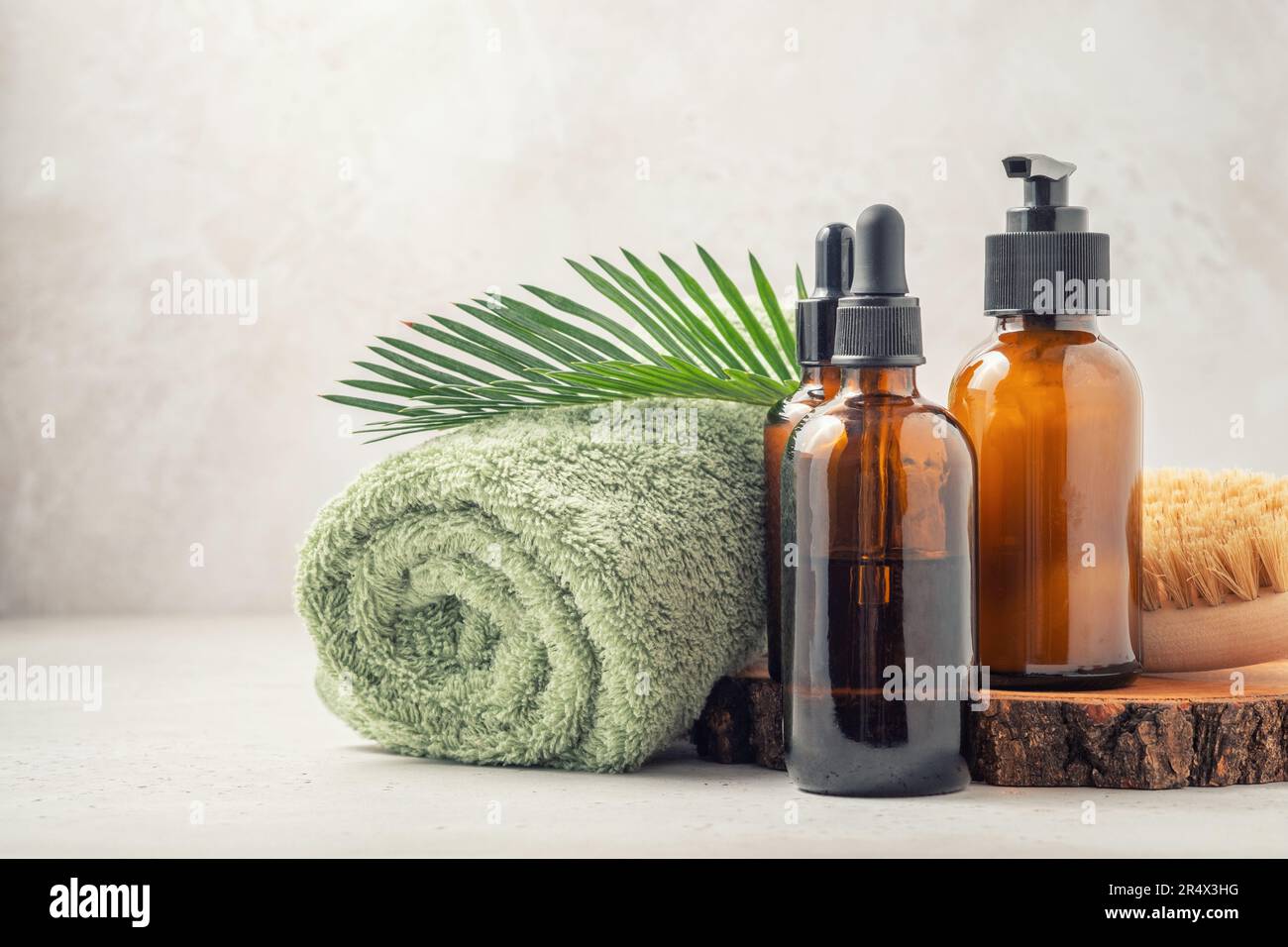 Bottles of dark amber glass with essential oil, massage brush and ...