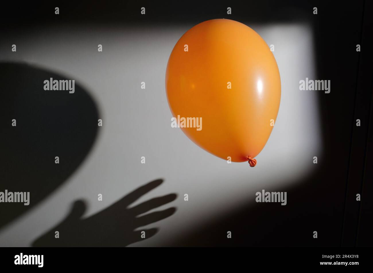 Abstract Orange Balloon With Shadow and Hand Shadow Stock Photo - Alamy