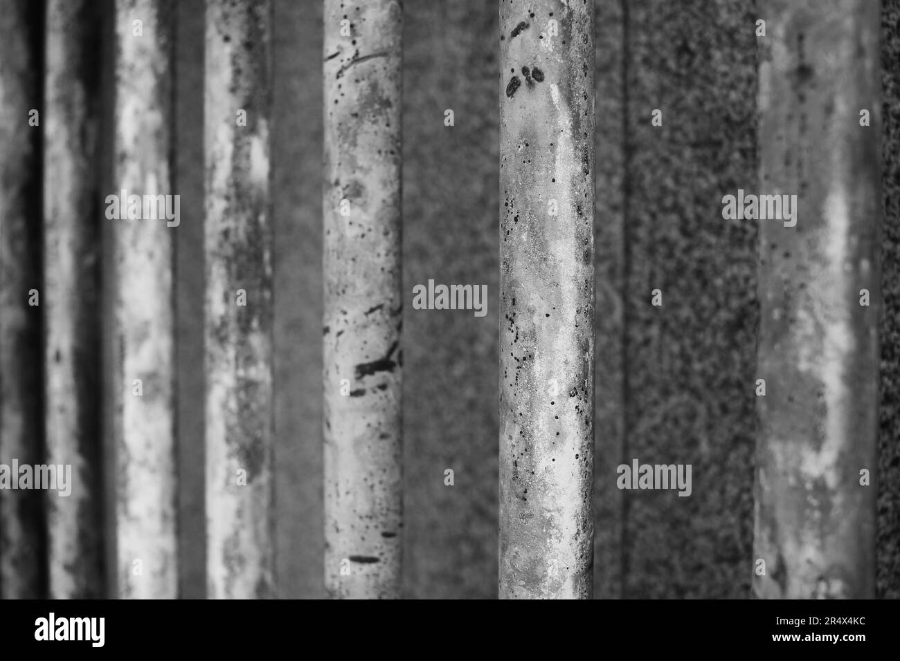 Vertical metal prison bars protecting the room inside in a black and ...
