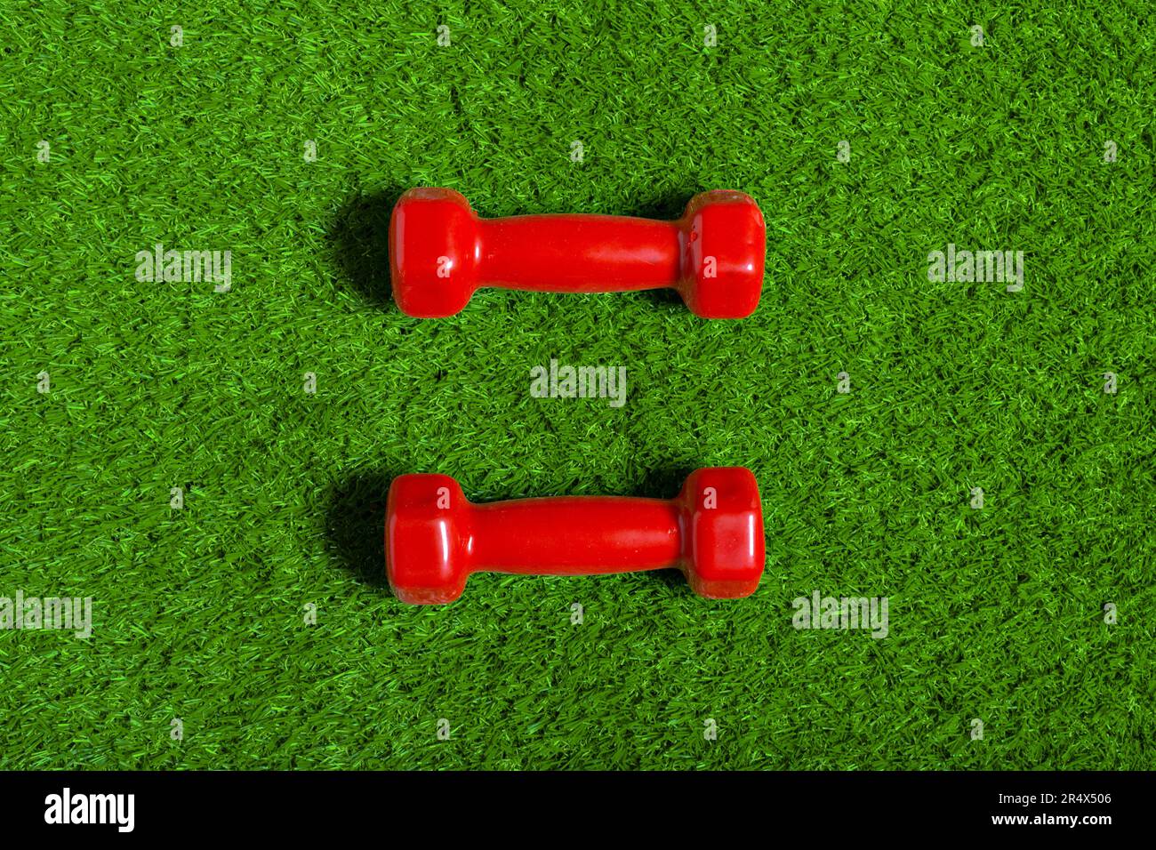 red dumbbell on green grass Stock Photo - Alamy