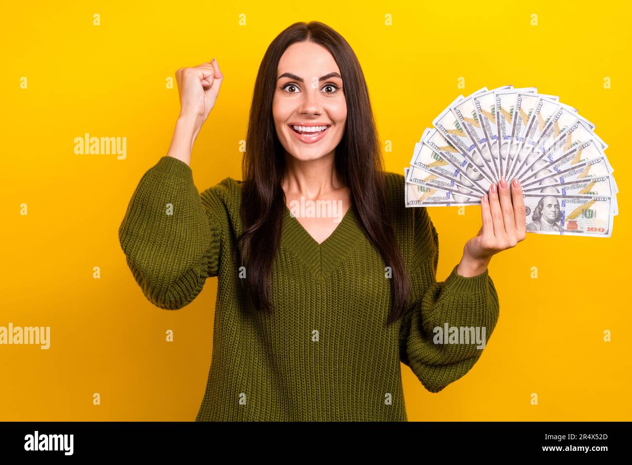 Photo of delighted crazy person raise fist hold dollar banknotes bills ...