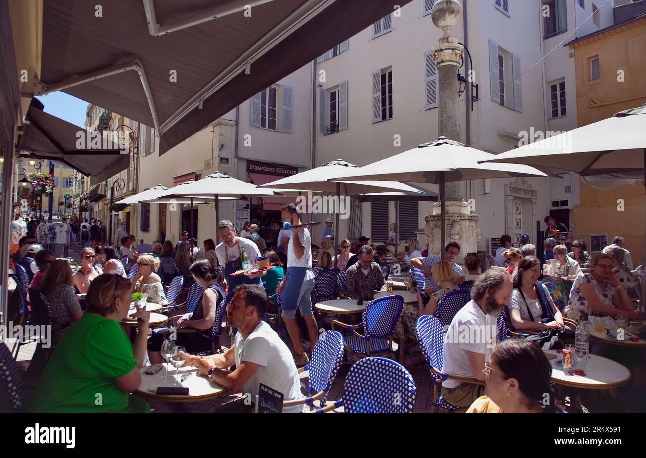France, Provence-Alpes-Cote d'Azur, Antibes, Tourists sat outside cafes ...
