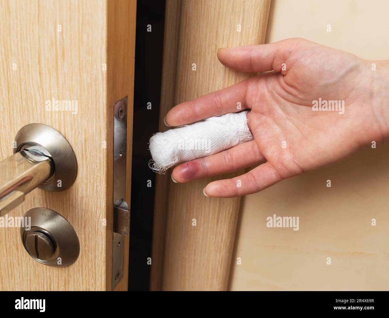 A bandaged finger against the background of an ajar door in the room, a ...