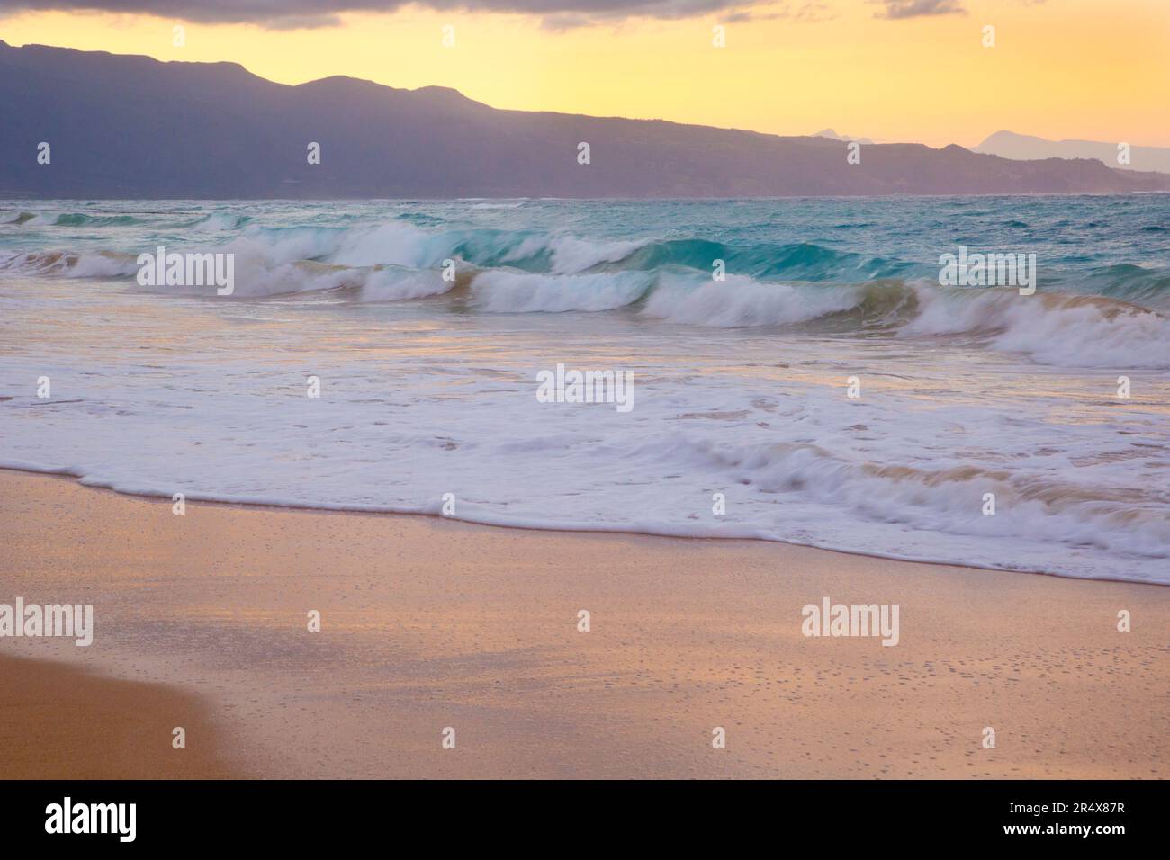 Close-up of foamy surf and turquoise waves breaking on the sandy ...