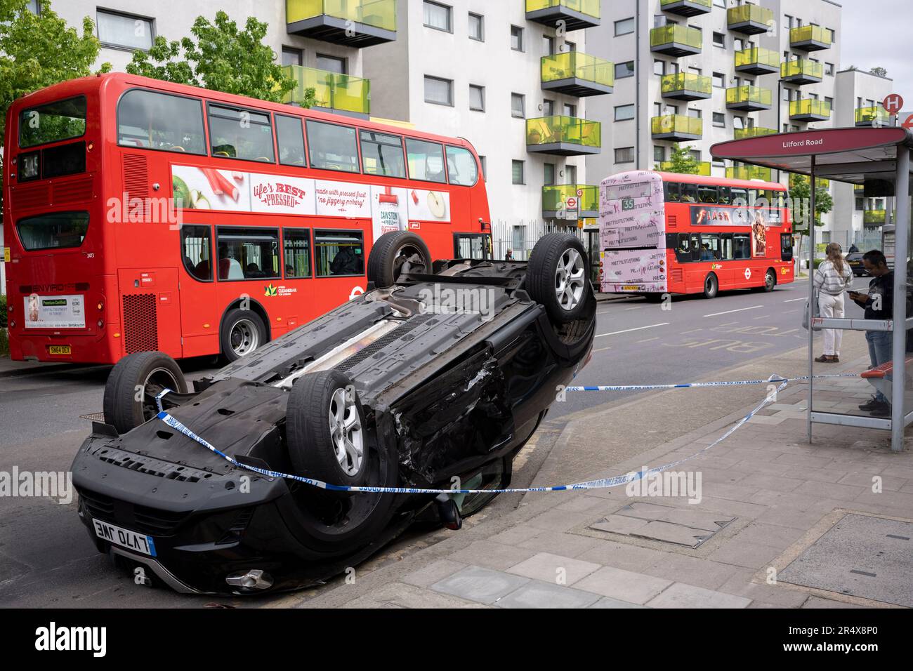 A London bus passes the aftermath of a car crash in which an overturned ...