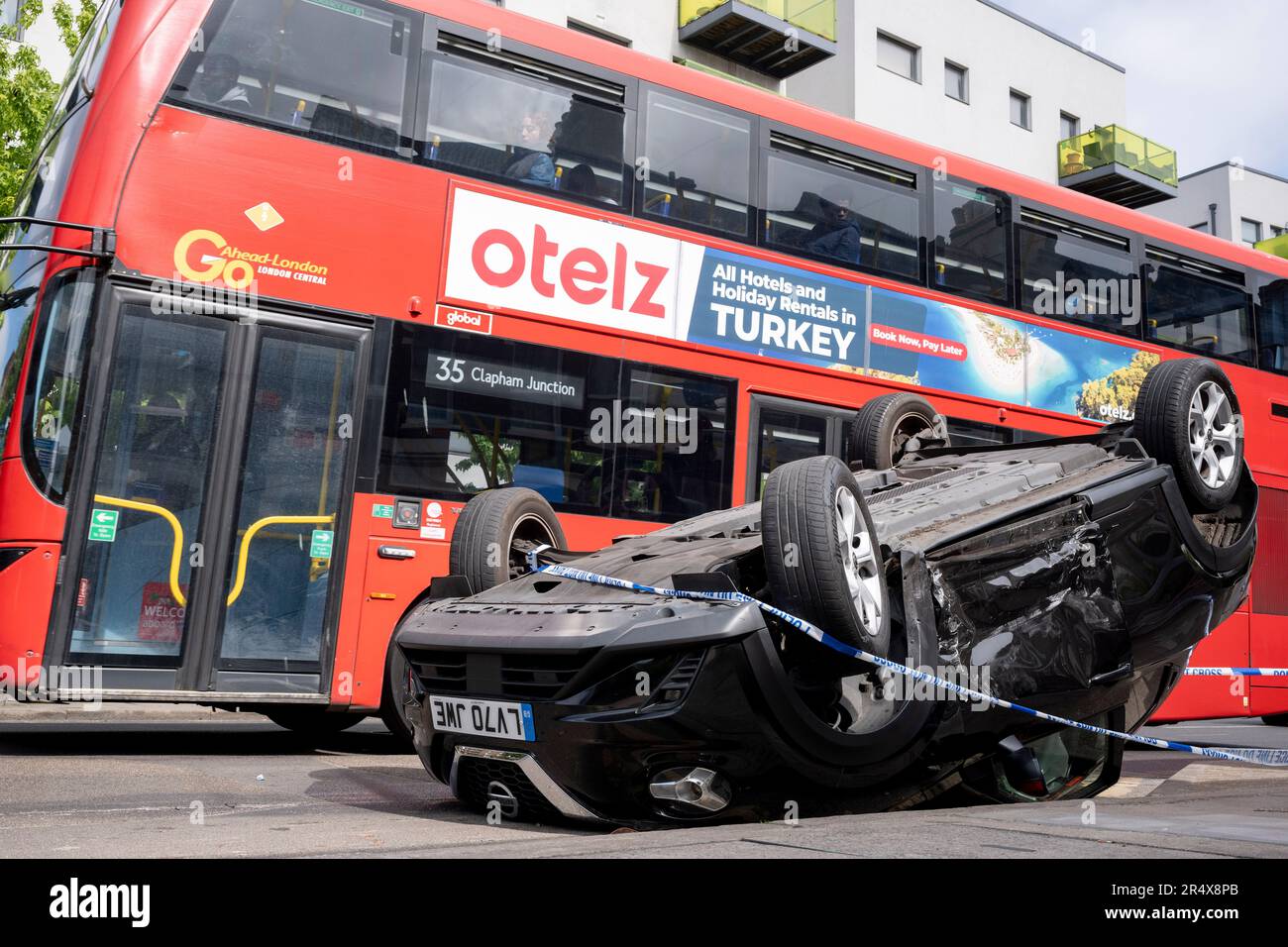 A London bus passes the aftermath of a car crash in which an overturned ...