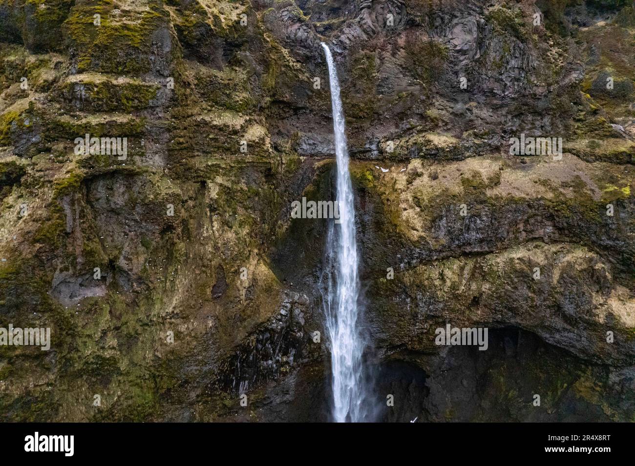 Close-up of a plunging waterfall against the rocky cliffs in the hikers ...