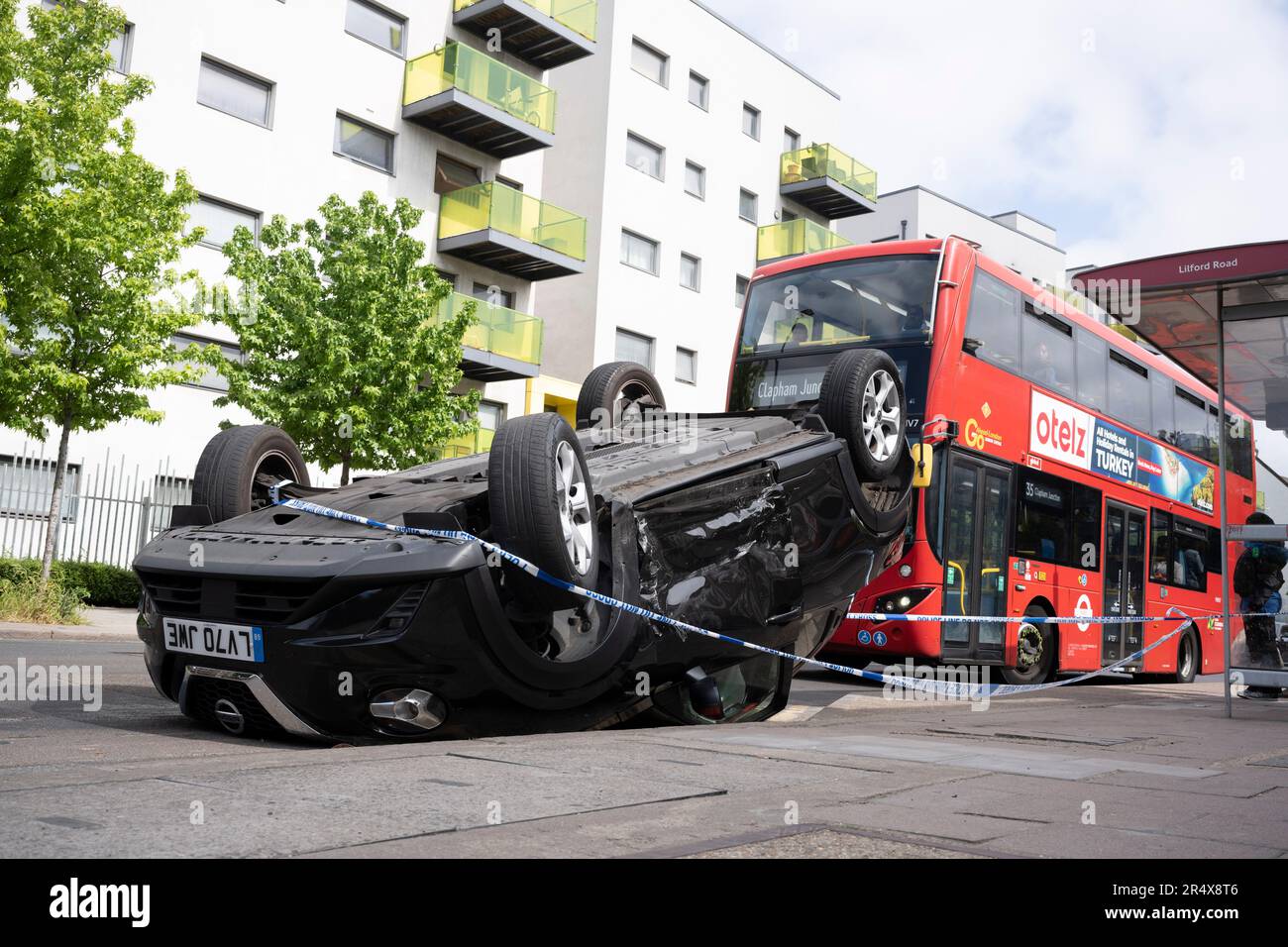 A bus approaches the aftermath of a car crash in which an overturned ...